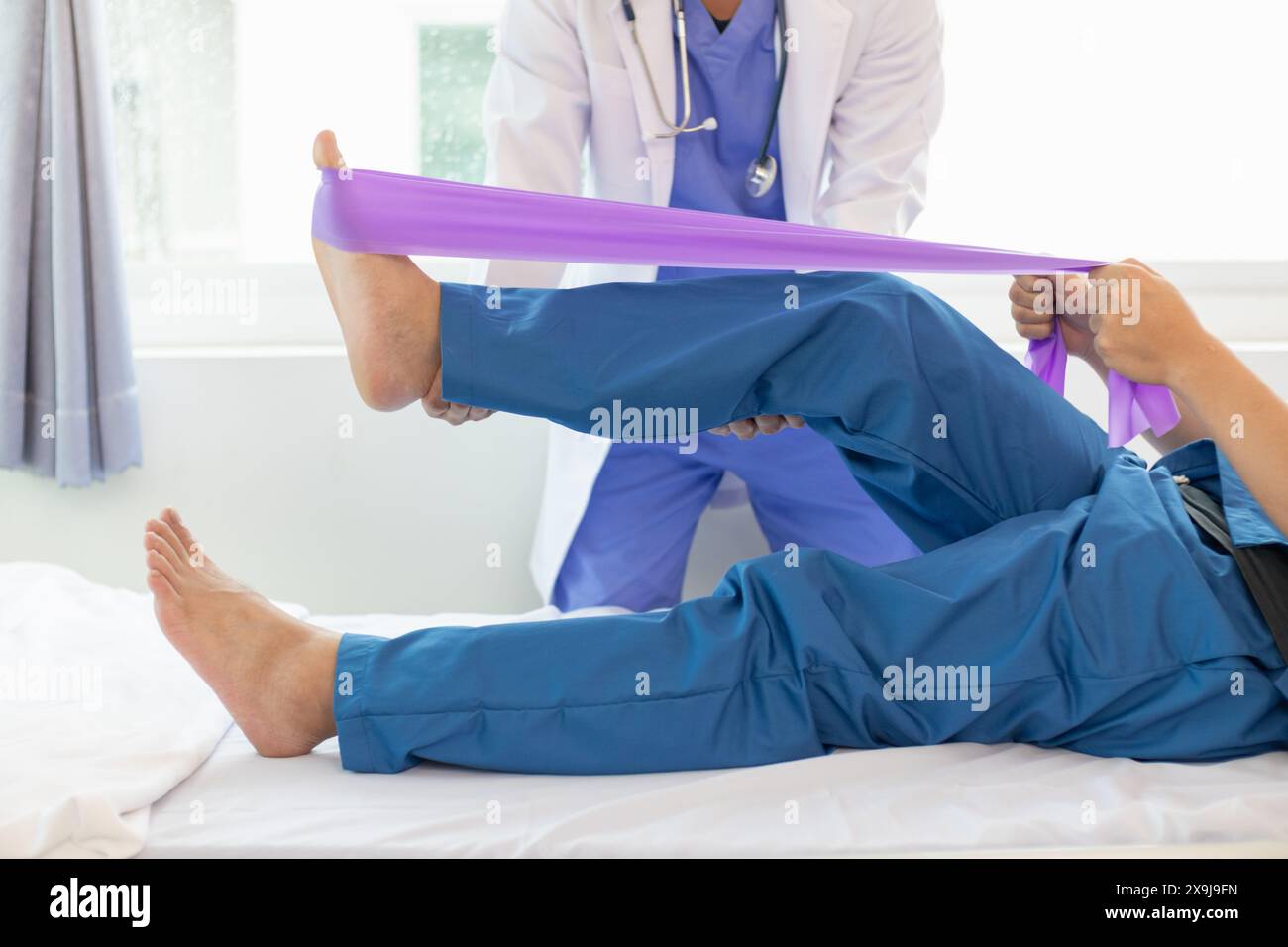 female doctor using elastic bands help patient regain muscle movement ...