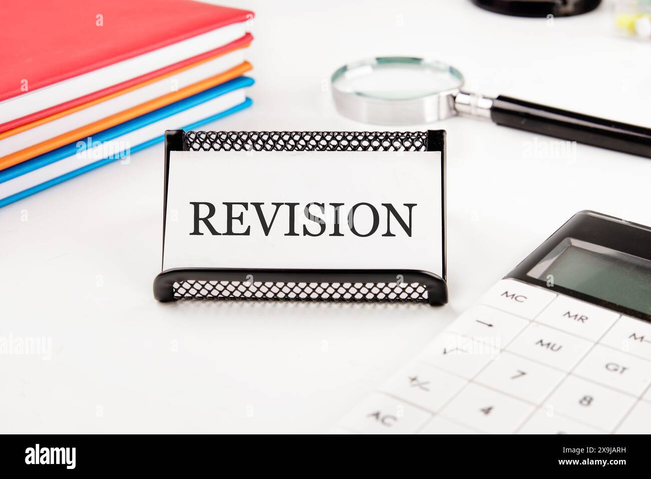 Concept Word REVISION on a business card in a composition with a ...