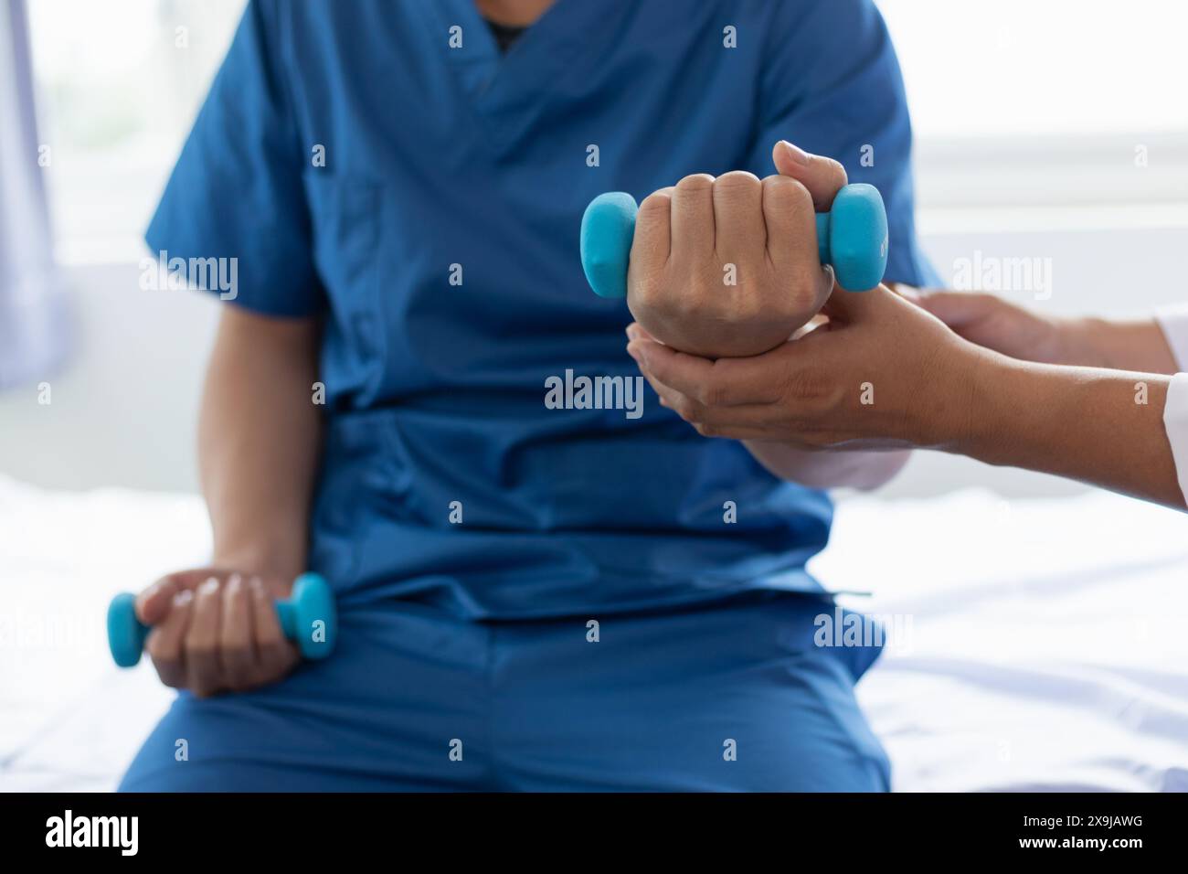 doctor is helping a patient move her muscles after recuperating from a ...