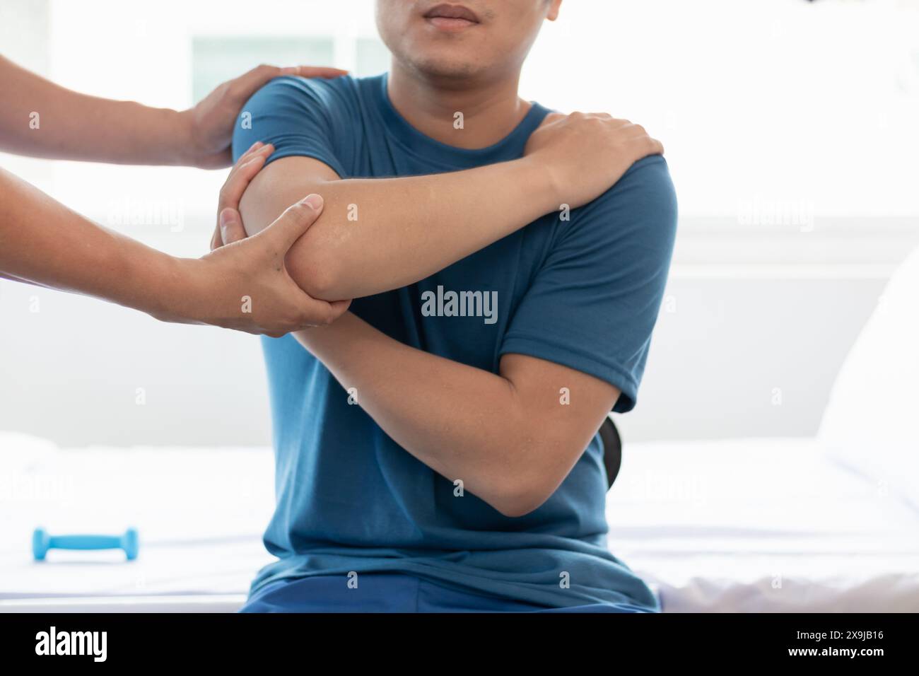 doctor is helping a patient move her muscles after recuperating from a ...