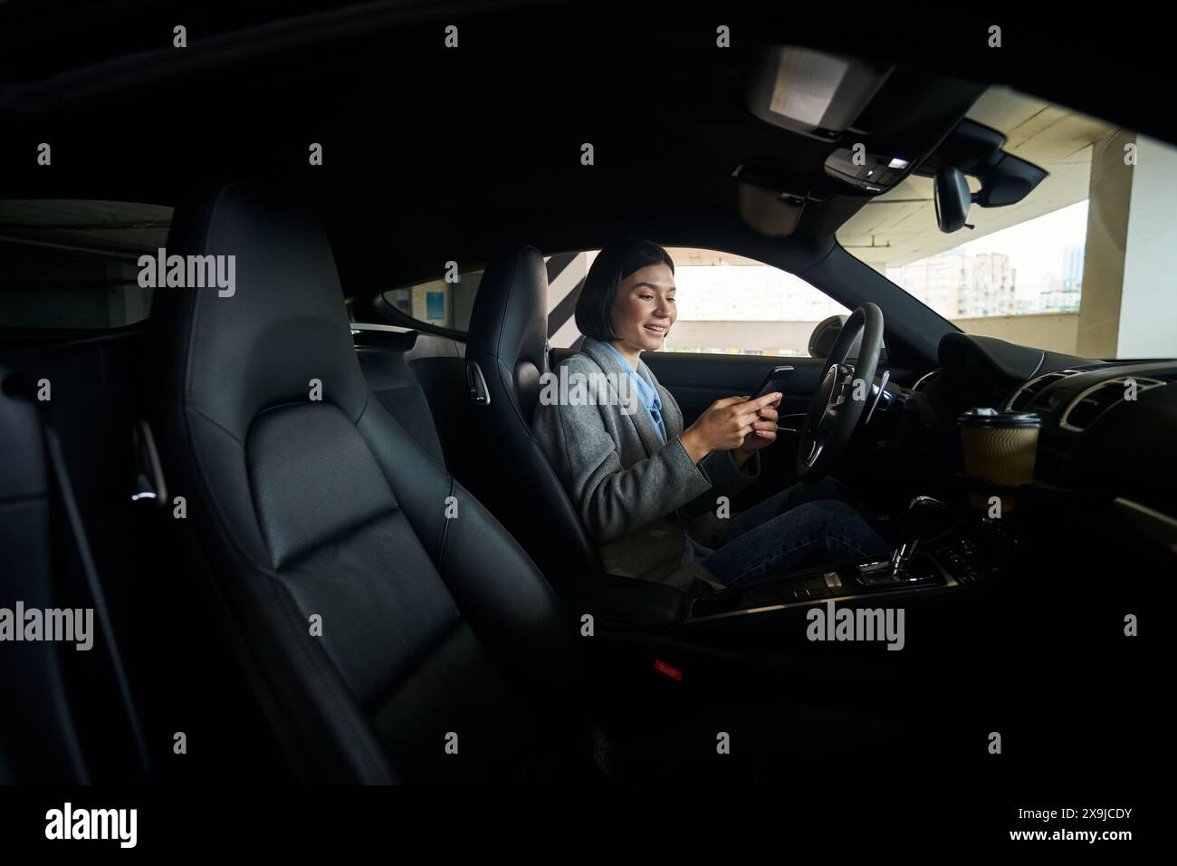 Happy lady driver using her smartphone in car Stock Photo - Alamy