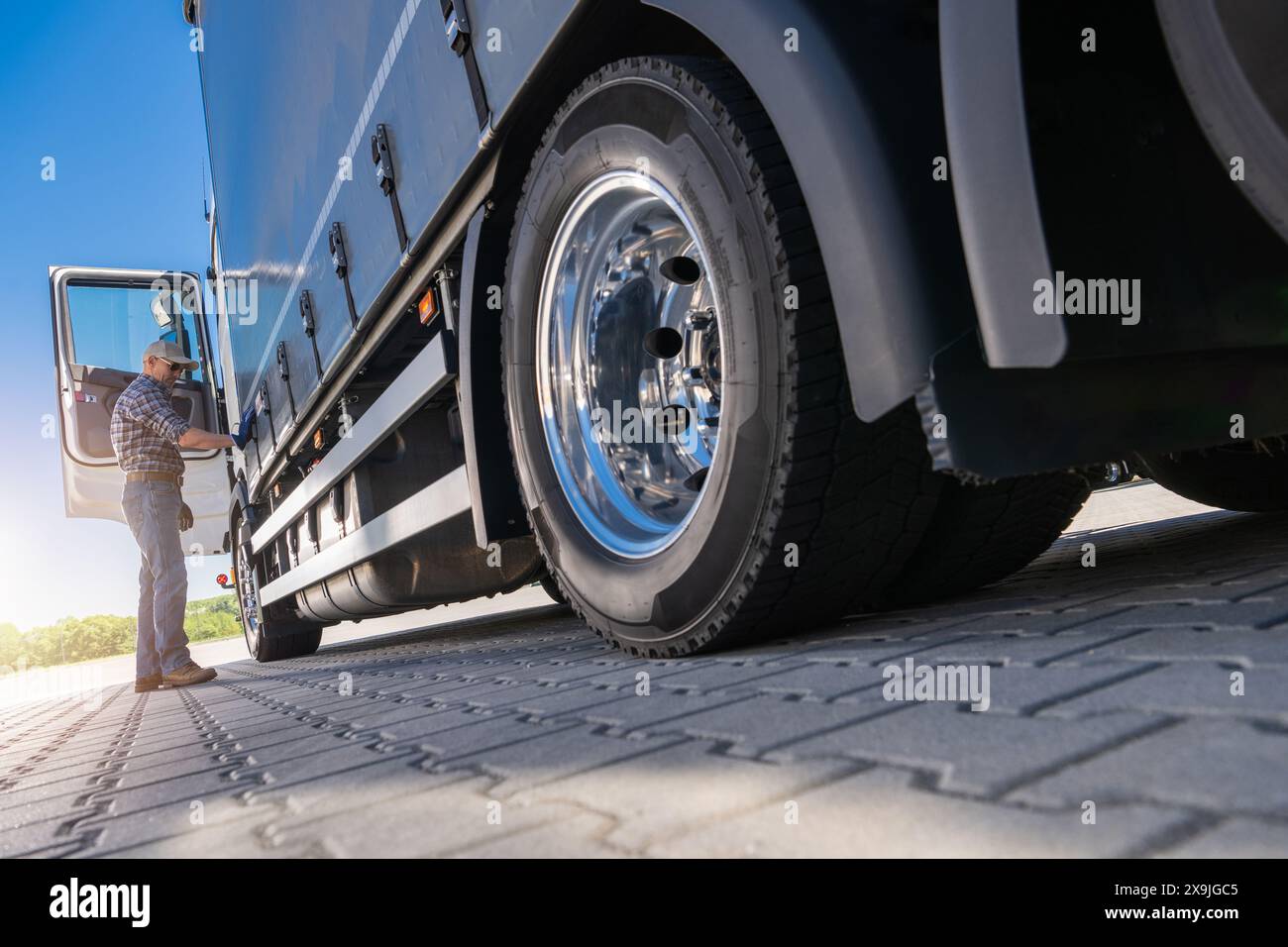 Trucker Inspecting Semi-Trailer Tire Stock Photo - Alamy