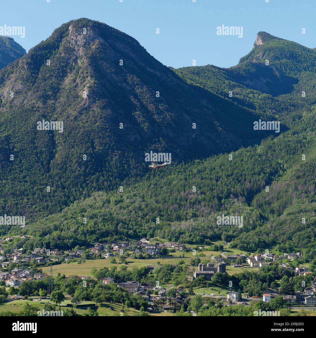 Town of Fenis and its castle beneath towering mountains in the Aosta ...