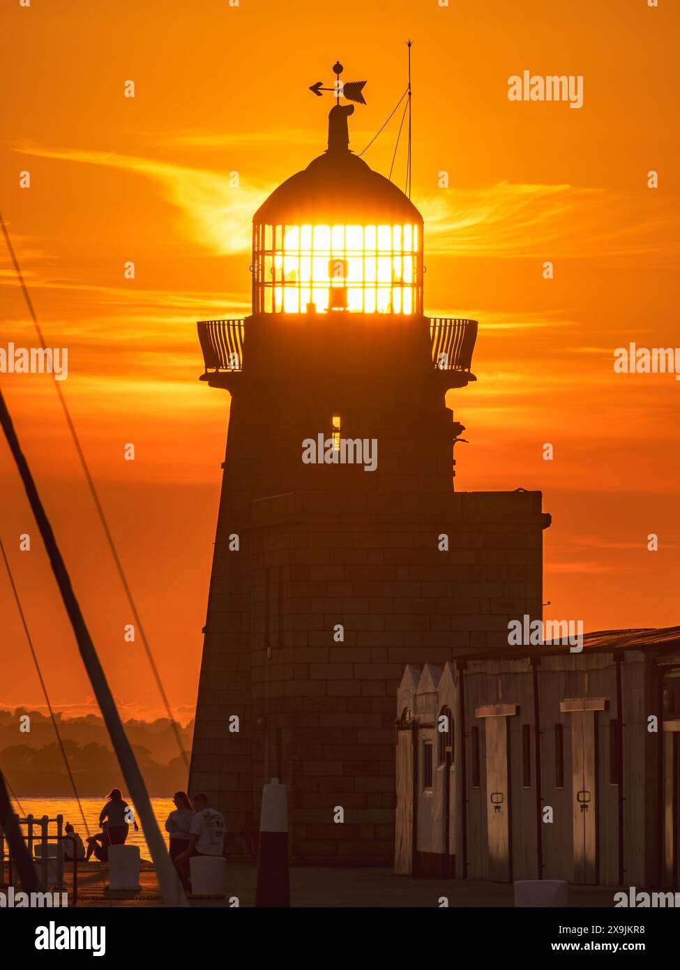 Sunset lined up with Howth Lighthouse Stock Photo - Alamy