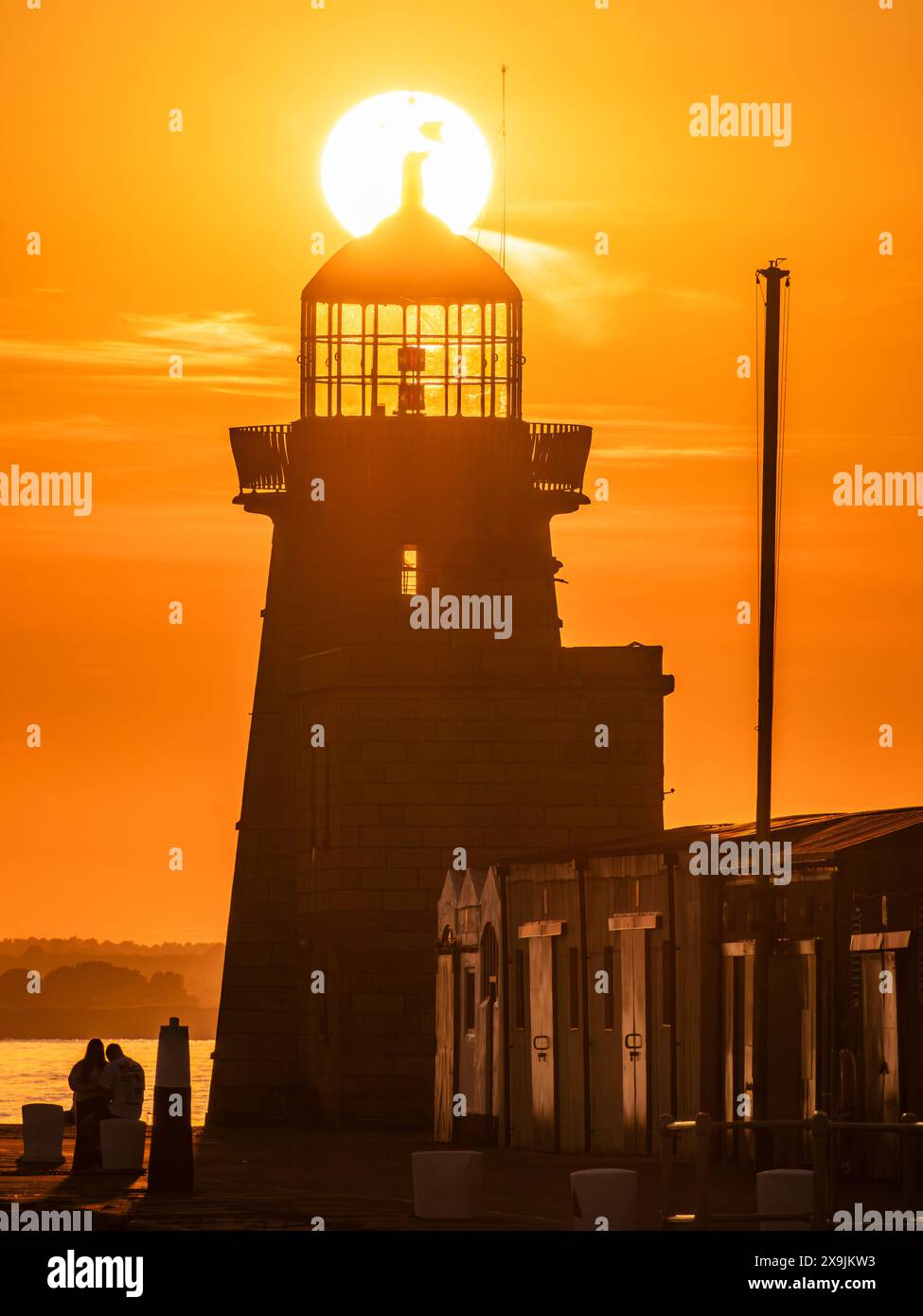 Sunset lined up with Howth Lighthouse Stock Photo - Alamy