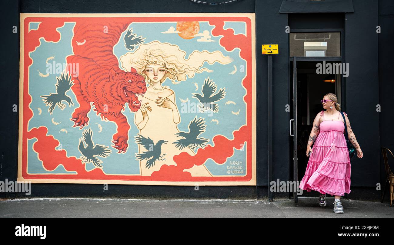 A person exits a restaurant next to a fresh graffiti artwork at the ...