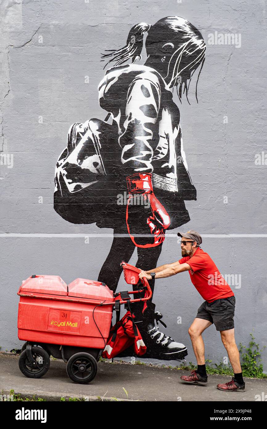 A Royal Mail worker passes a new graffiti artwork at the Upfest ...