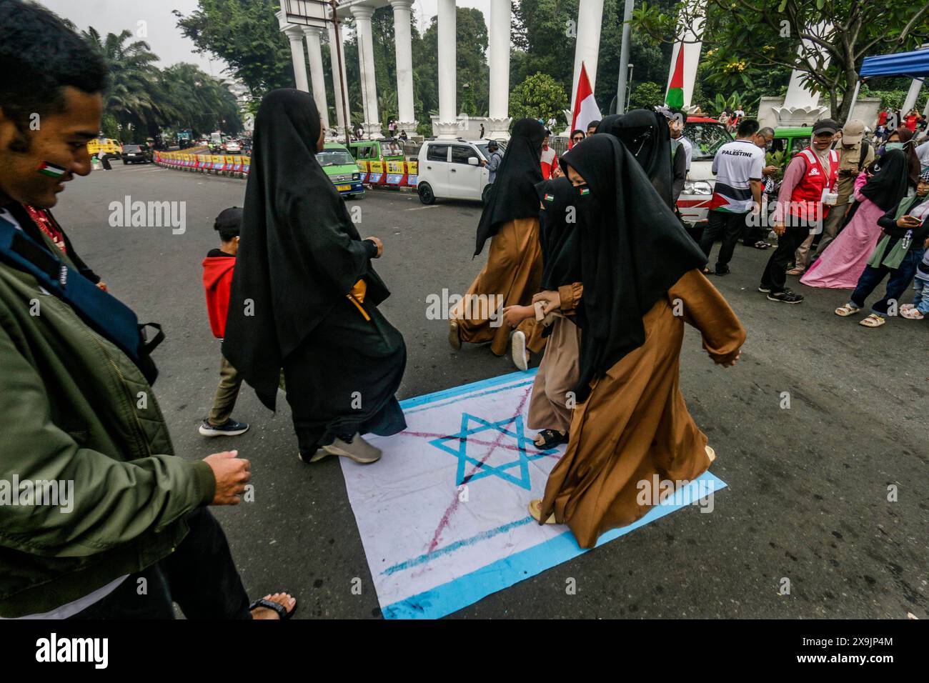 Pedestrians step on an Israeli flag during a pro-Palestinian ...