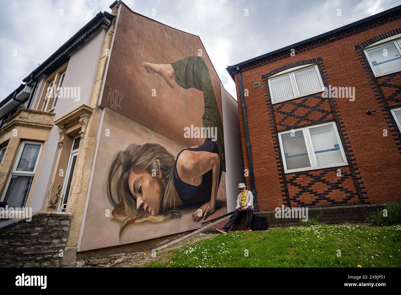 A man sits next to a fresh graffiti artwork at the Upfest Presents ...
