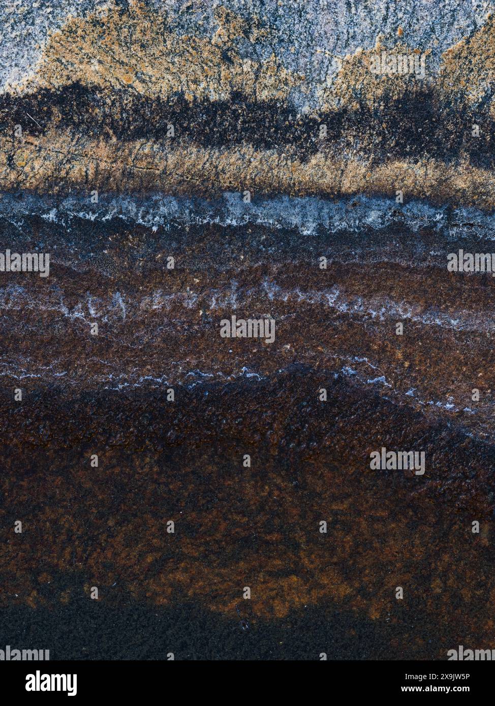 A close-up view of a coastal cliff, showcasing the intricate layers of ...