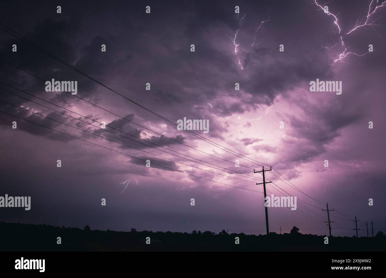 A fierce lightning bolt streaks across the sky behind the silhouettes ...