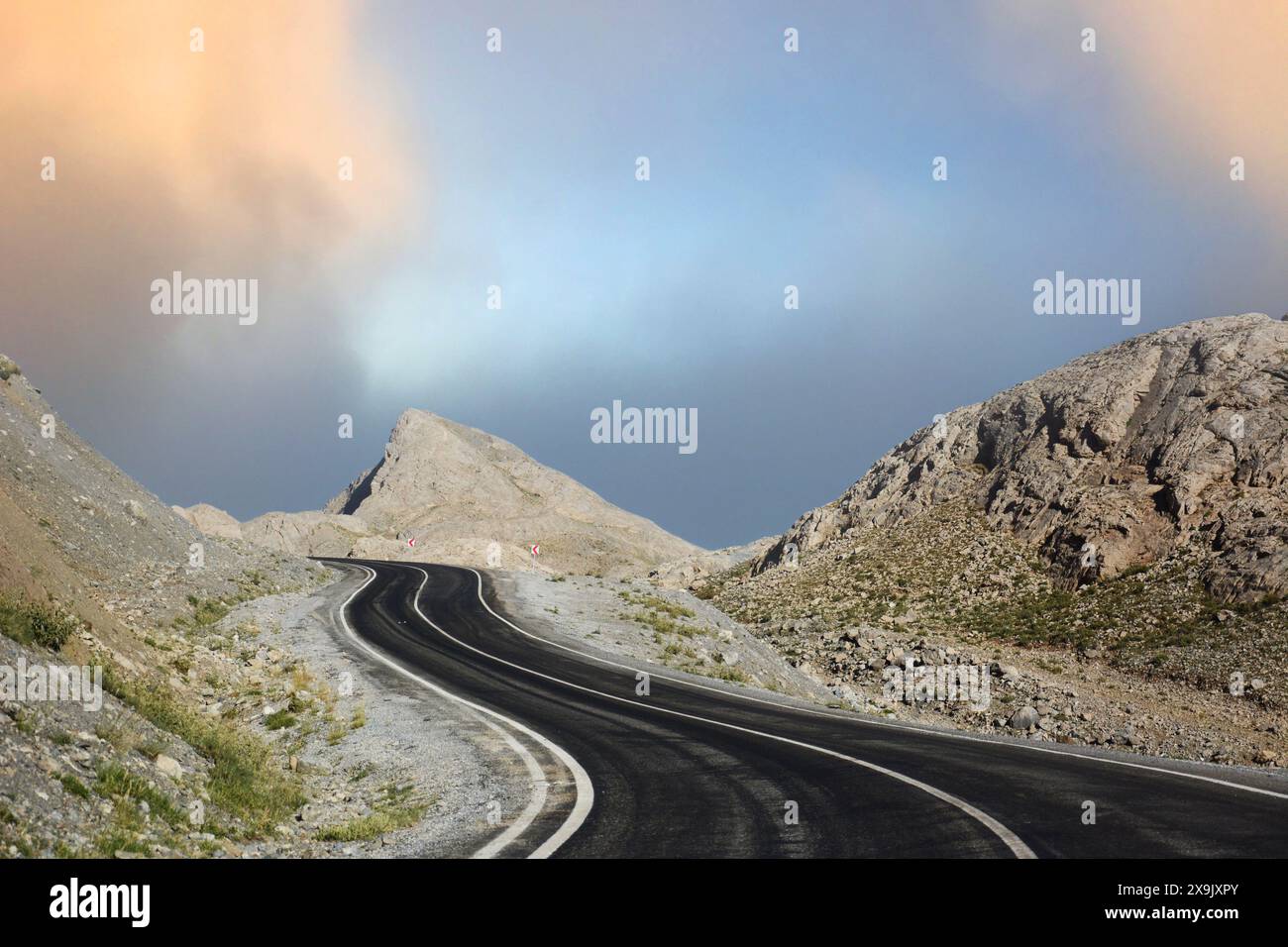 Curving Mountain Road at Dusk with Dramatic Sky. Embrace the Adventure ...