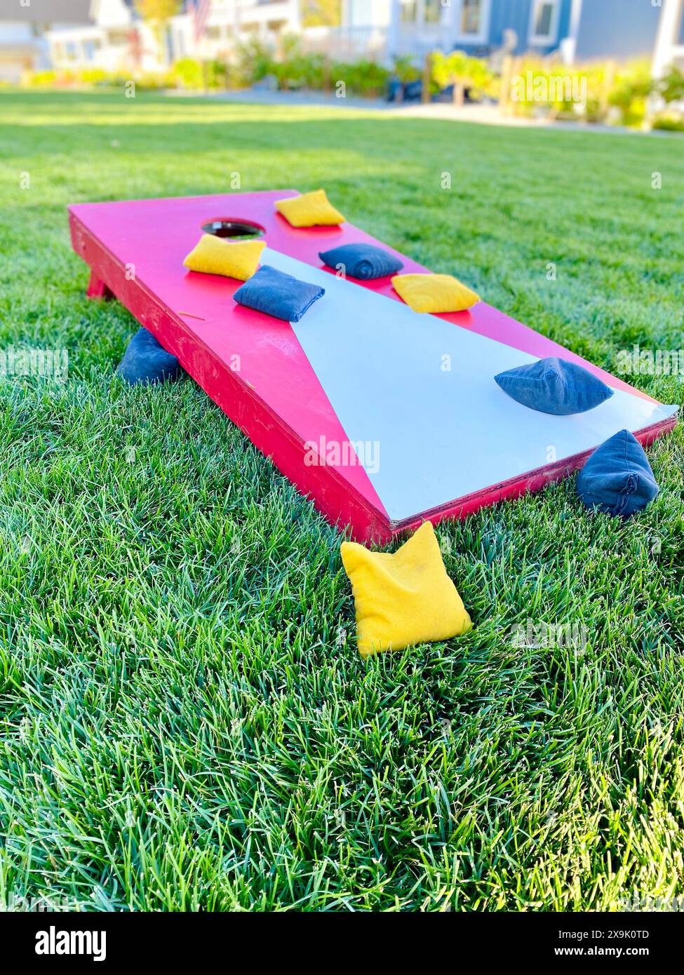 Red cornhole board lawn game leisure activity with bean bags on grass ...