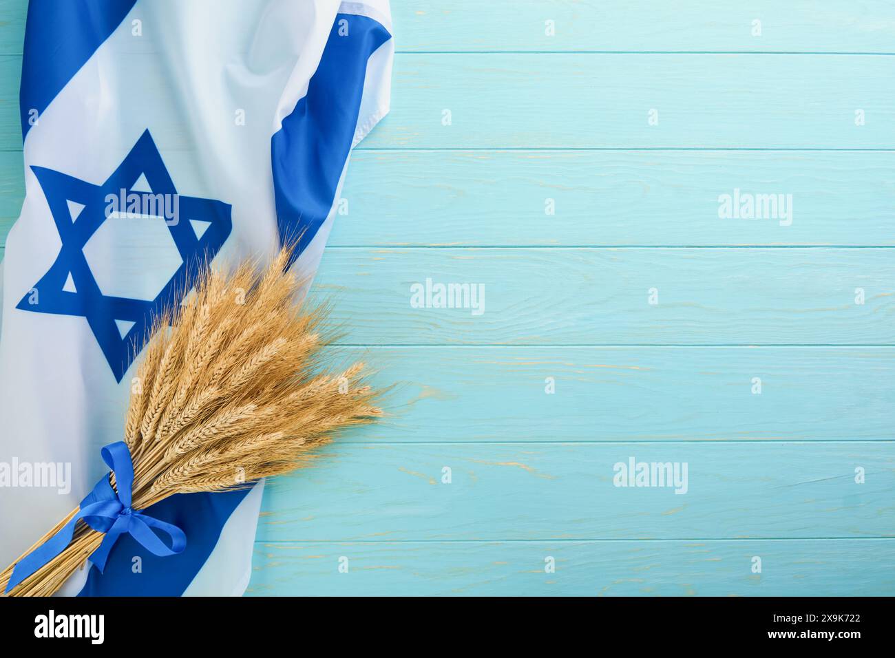 Shavuot jewish background. Ripe bouquet of wheat with blue ribbon with ...