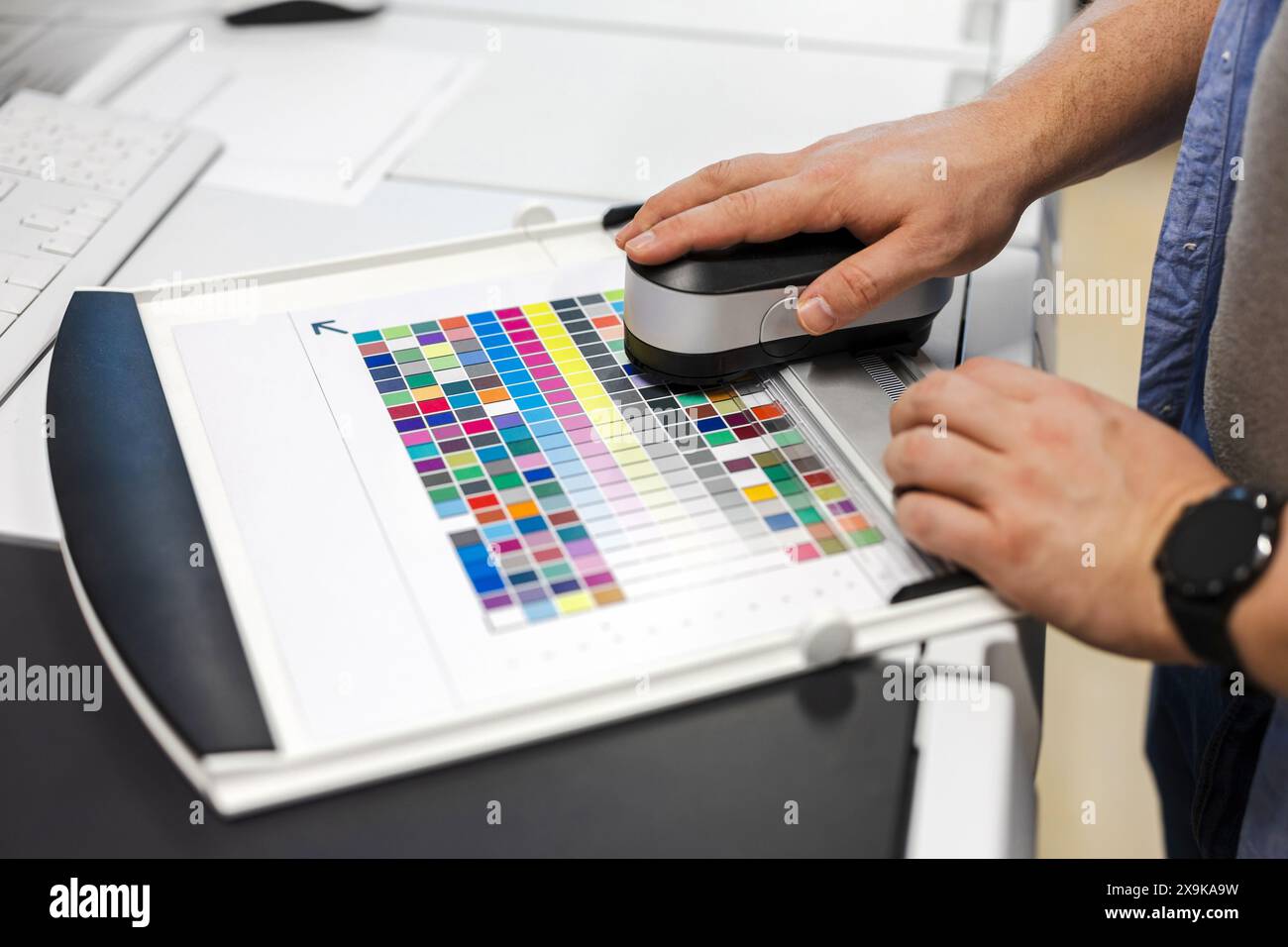 Printing factory worker with color reference card Stock Photo - Alamy