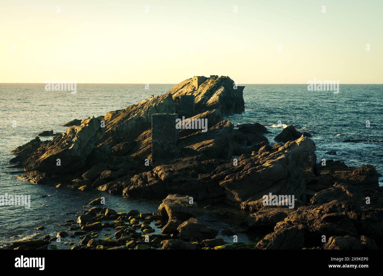 coastal landscape in which an old loading dock juts into the sea, long ...