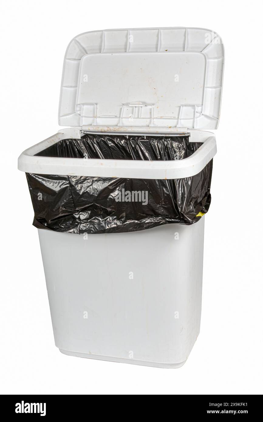 Vertical shot of a dirty kitchen trash can with lid open and holding a ...
