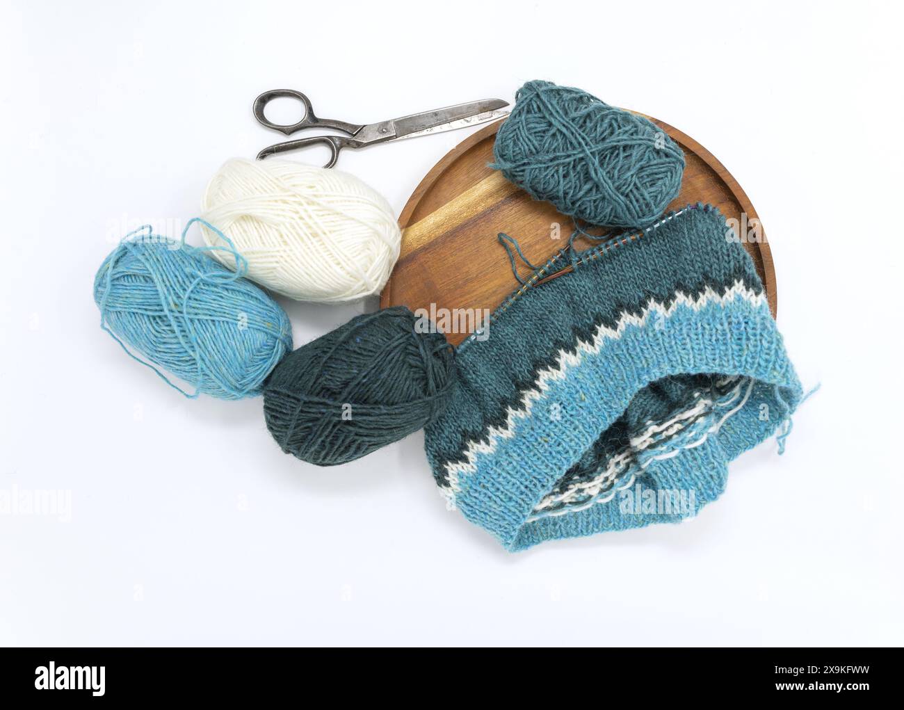 Flat lay photography of a turquoise white wool yarn knitting on a ...