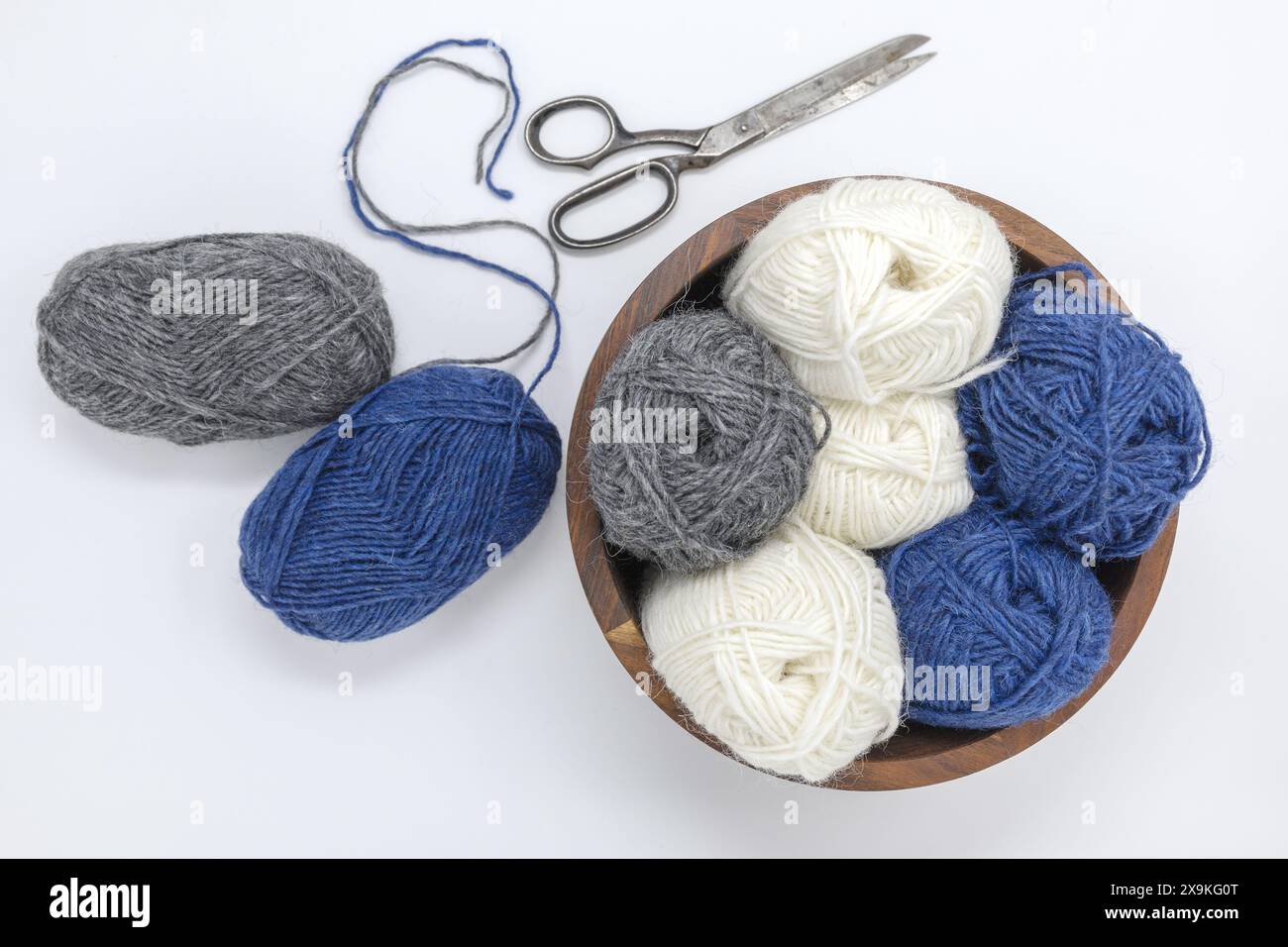 Flat lay photography of a blue grey white wool yarn balls in wooden ...