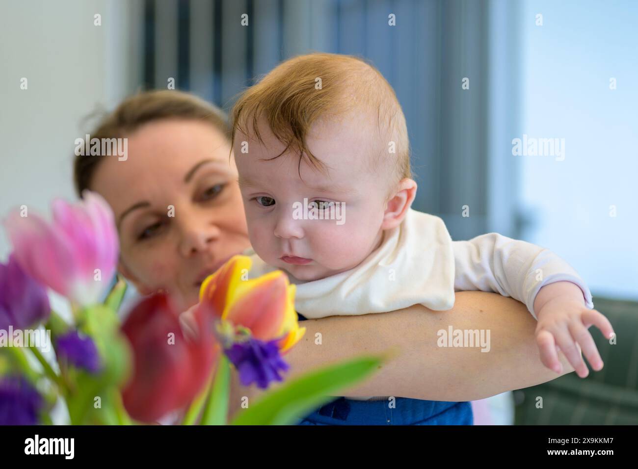 A touching moment of a mother holding her baby close as they explore a ...
