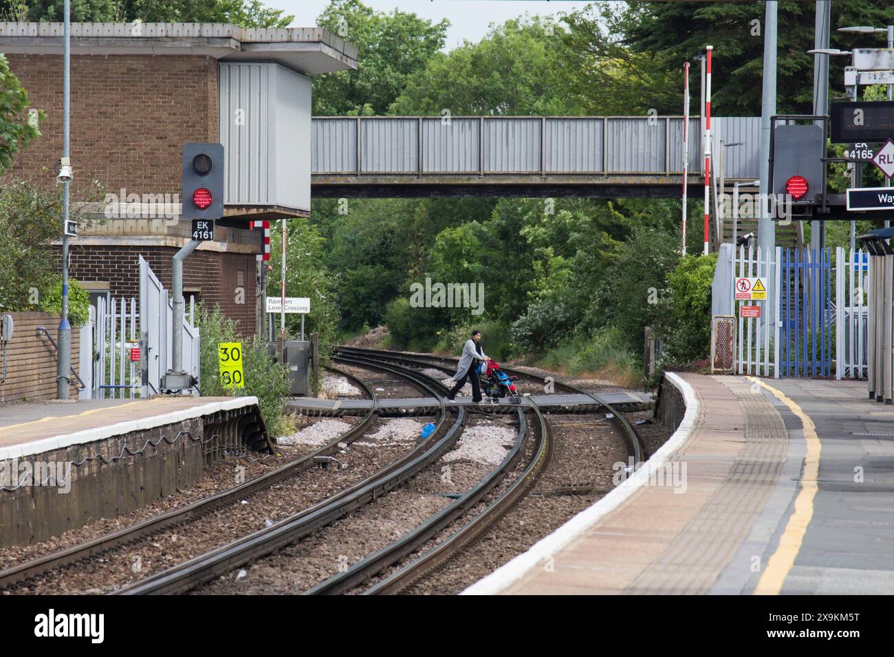 Railway level crossing Rainham Kent with a lady and pushchair crossing the tracks Stock Photo ...