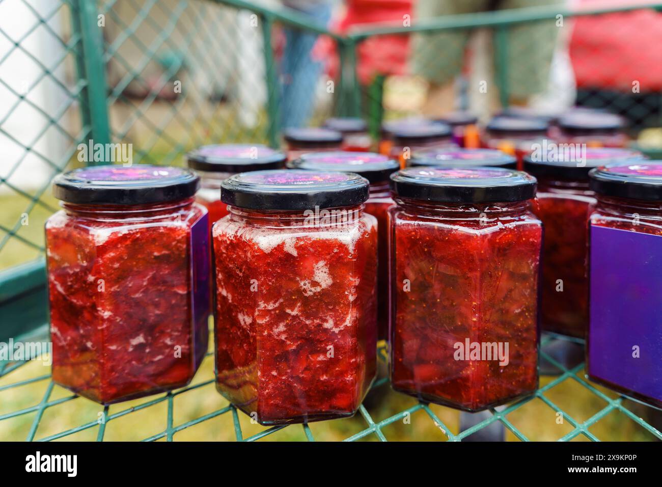 Collection of hexagonal jars with black lids filled with homemade ...