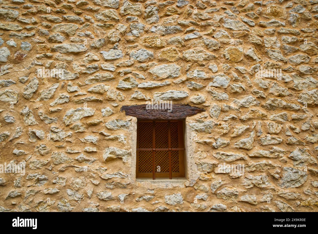 Beige stone brick wall made of sandstone with a window with wooden ...