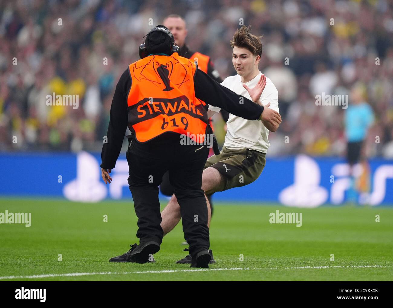 A pitch invader is tackled by stadium stewards during the UEFA ...