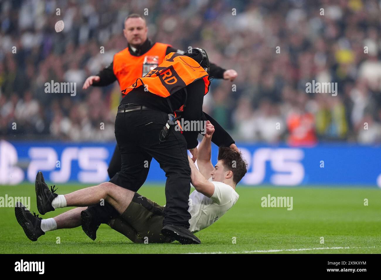 A pitch invader is tackled by stadium stewards during the UEFA ...