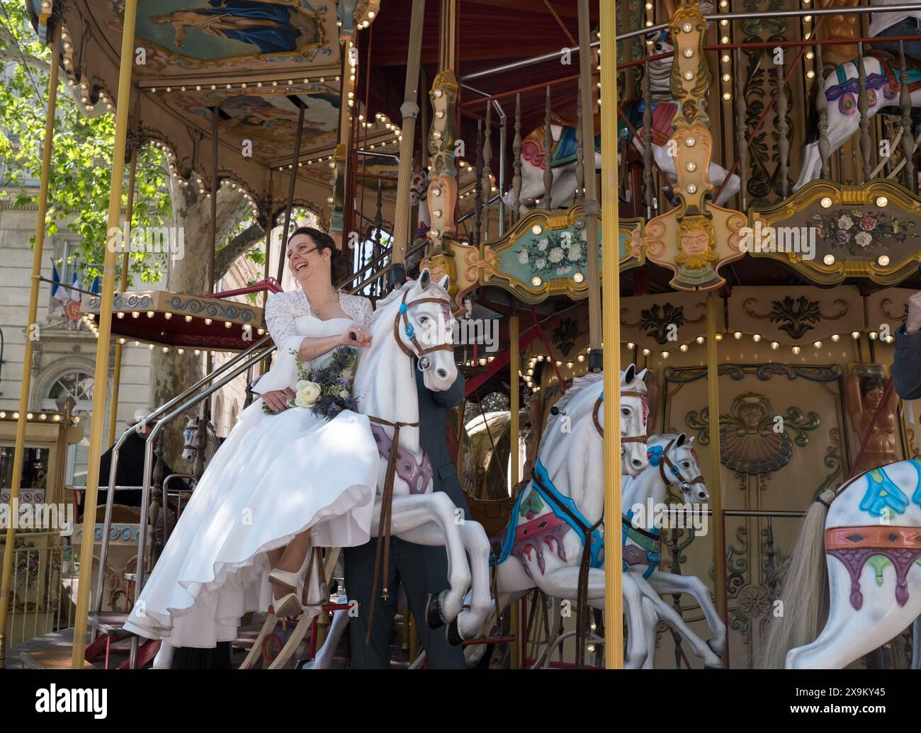 Bride riding a carousel after her wedding Stock Photo - Alamy