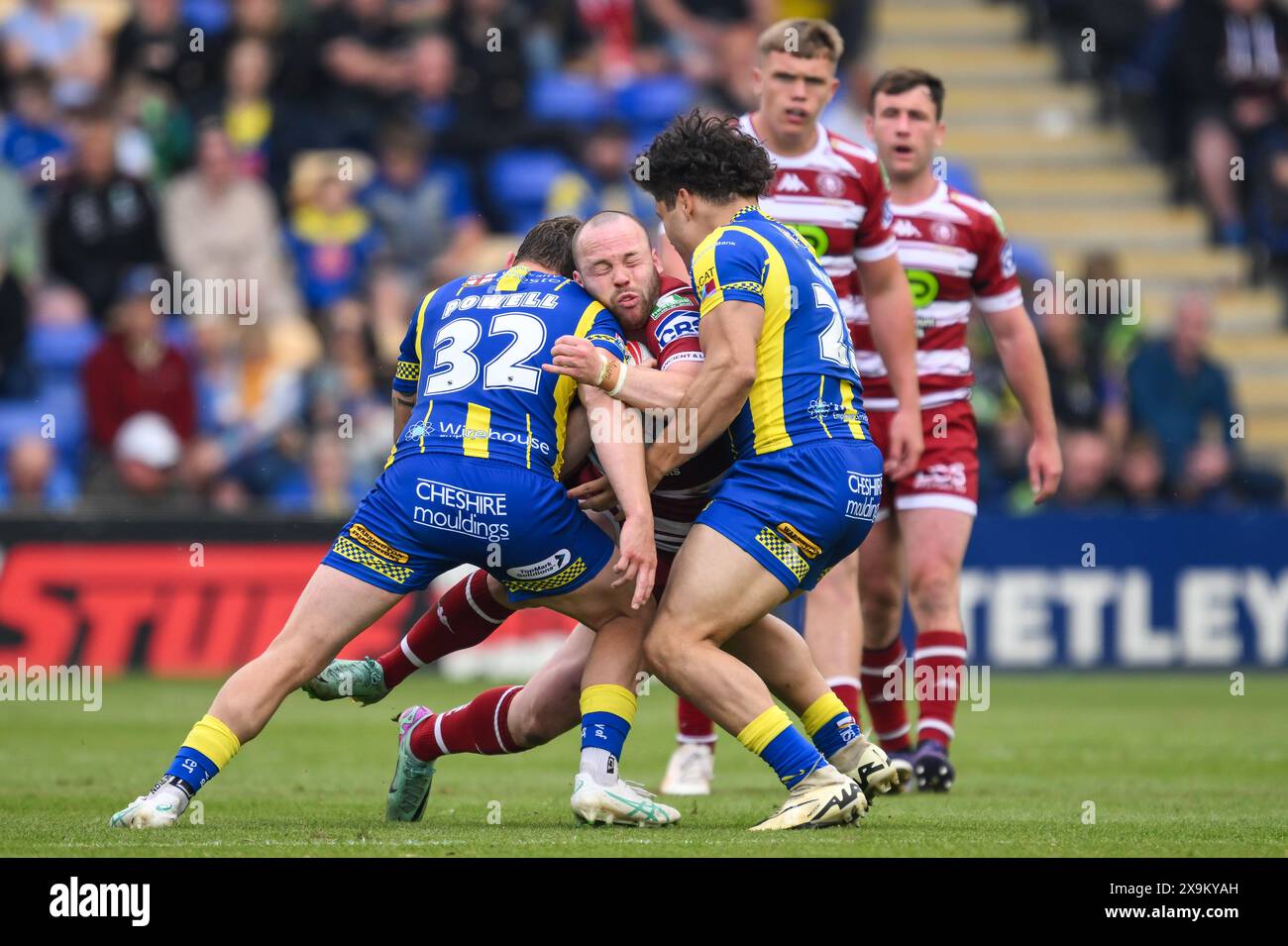 Liam Marshall of Wigan Warriors is tackled by Sam Powell of Warrington ...