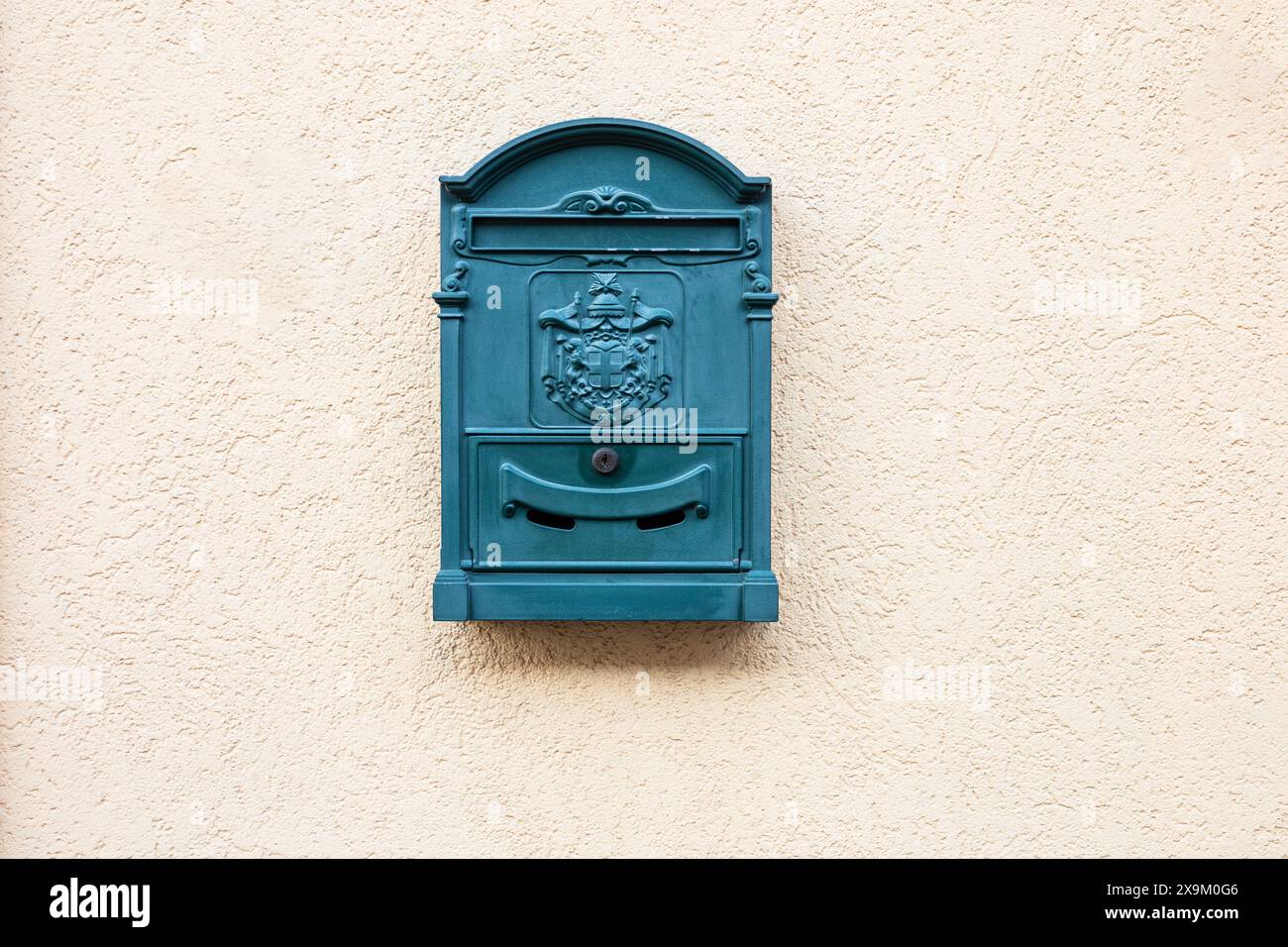 Traditional old turquoise post box on pastel plaster texture wall in ...