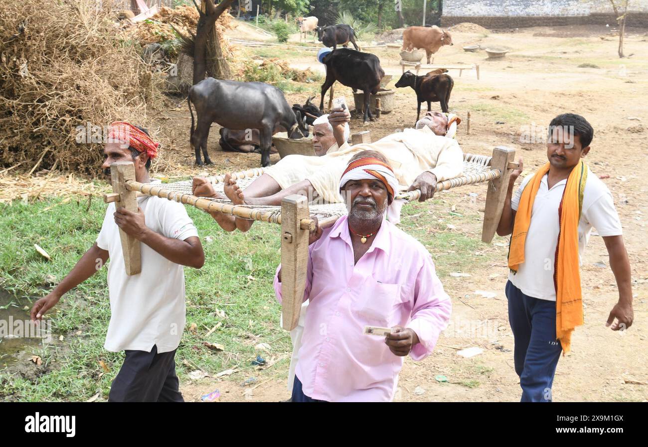 PATNA, INDIA - JUNE 1: Villagers carrying an old voter on 'Khatiya' for ...