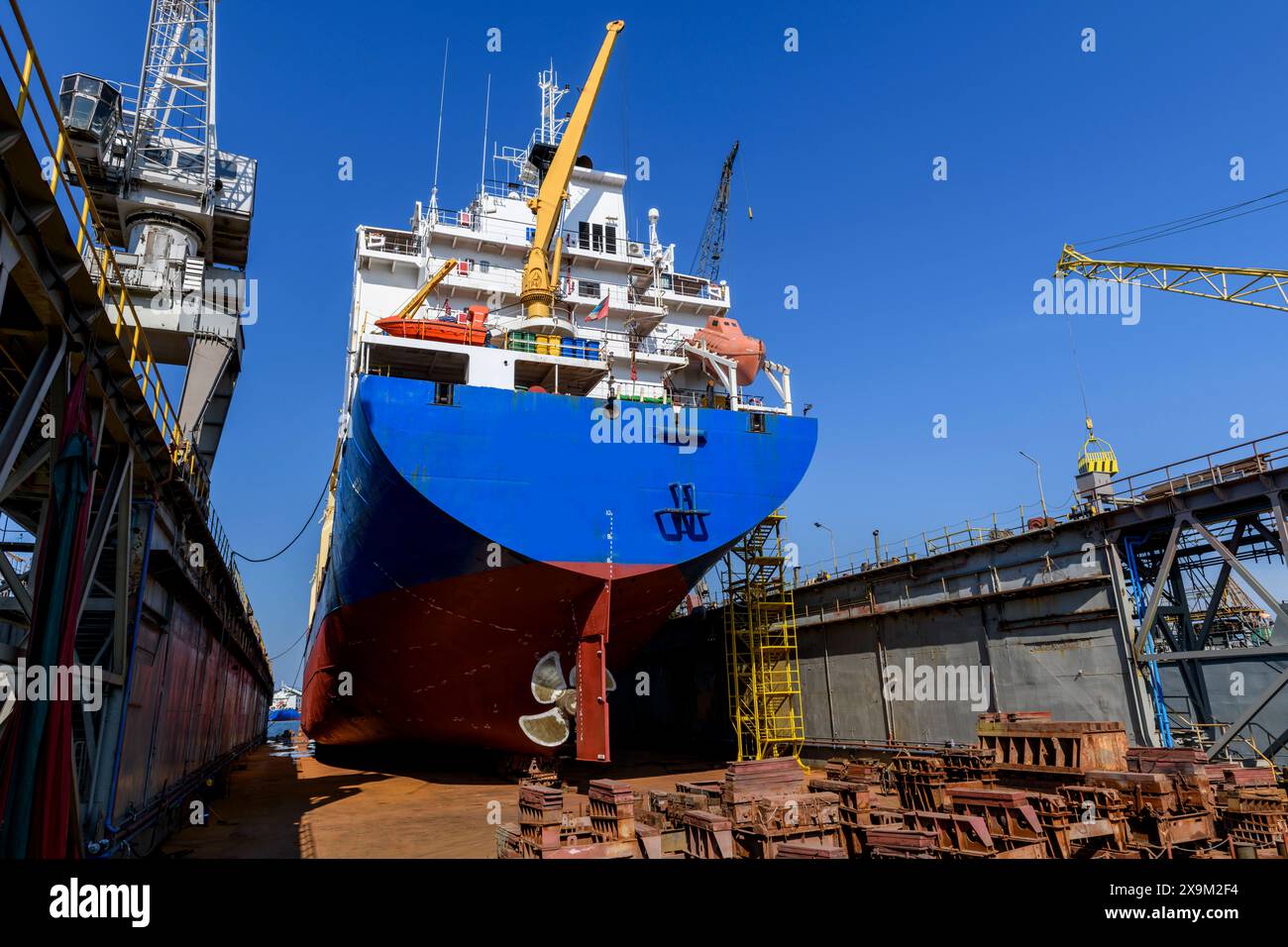 Cargo vessel in dry dock on ship repairing yard. Variable pitch ...