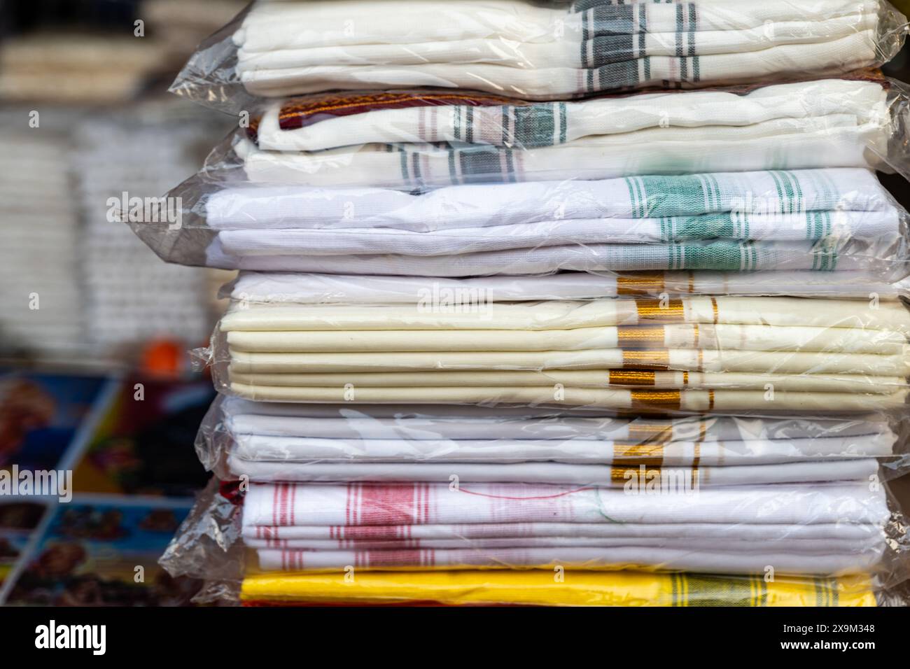 Close-up view of neatly stacked traditional dothi fabrics, showcasing ...