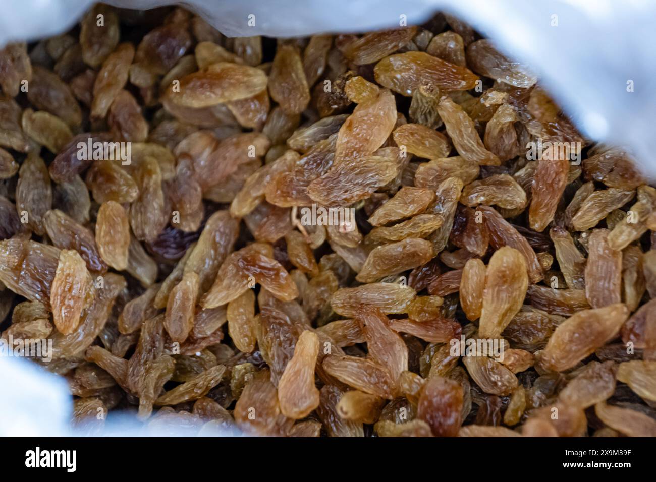 Close-up view of sun-dried grapes, their wrinkled surfaces hinting at a ...