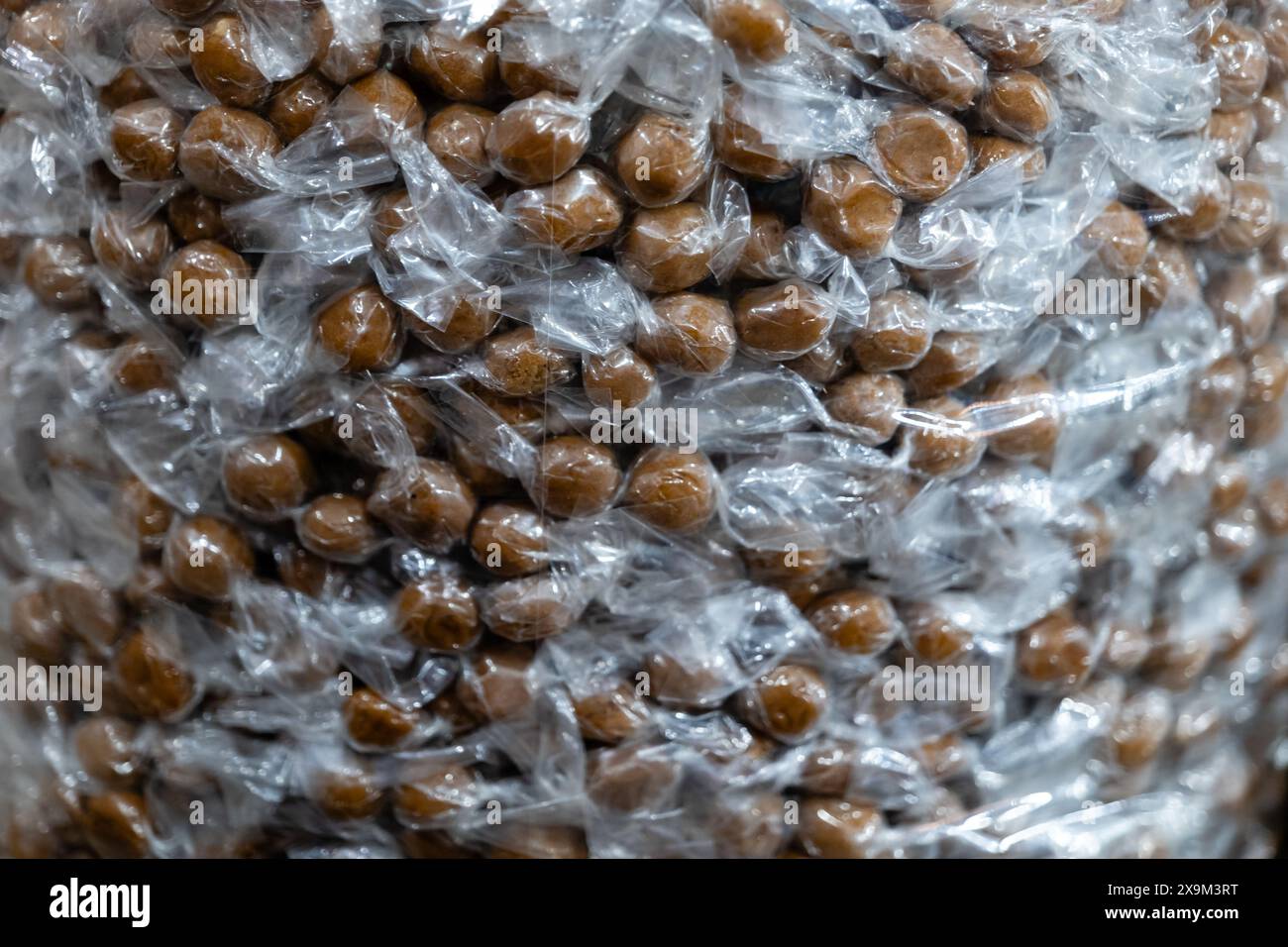 Close-up view of Pulipu candies individually wrapped in transparent ...