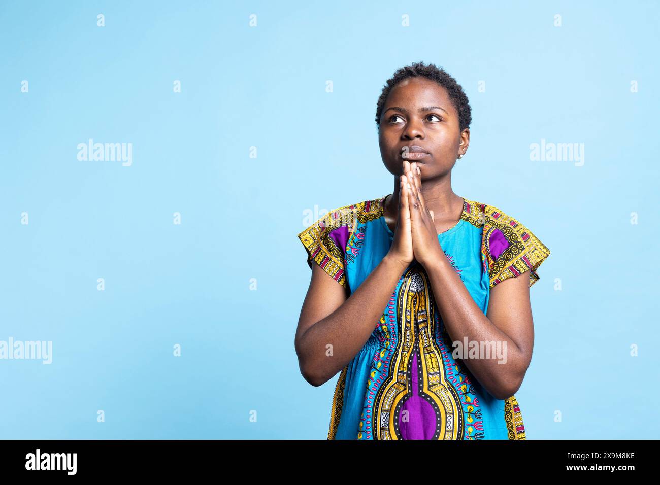 African american spiritual person holds hands in a prayer, praying to ...