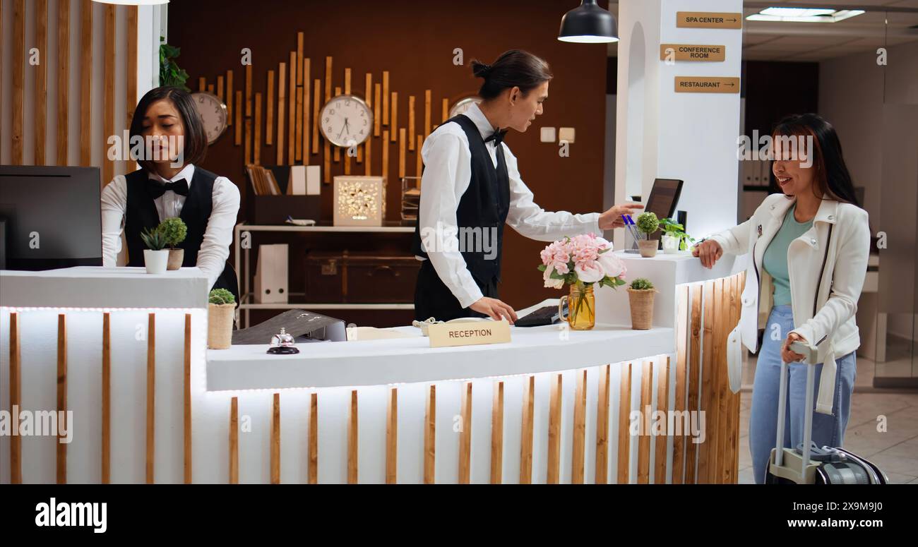 Hotel guest arriving at reception to do check in process, claiming room ...