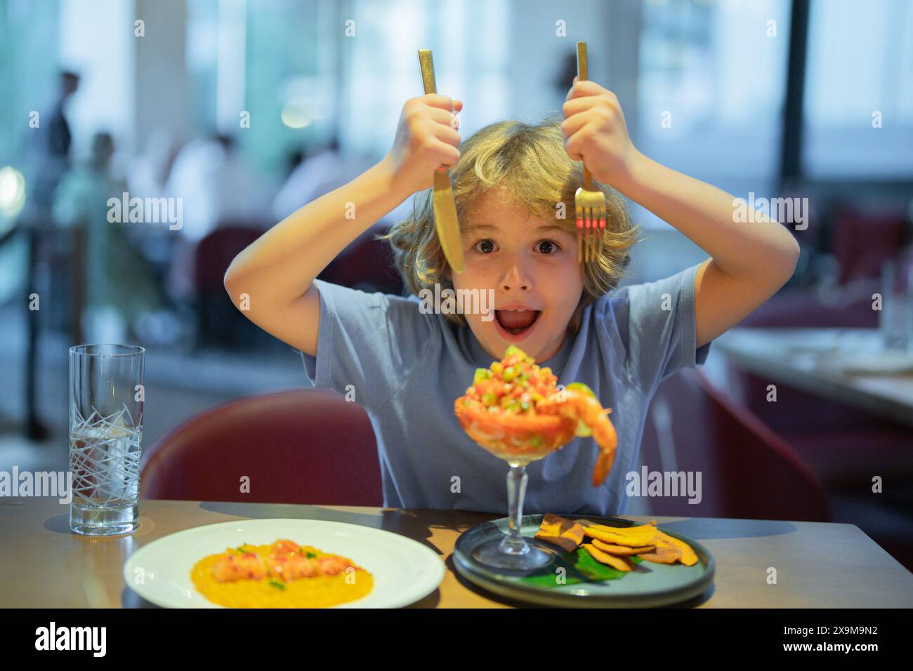 Funny surprised Little boy eating seafood in cafe. Kid eat Food fish ...