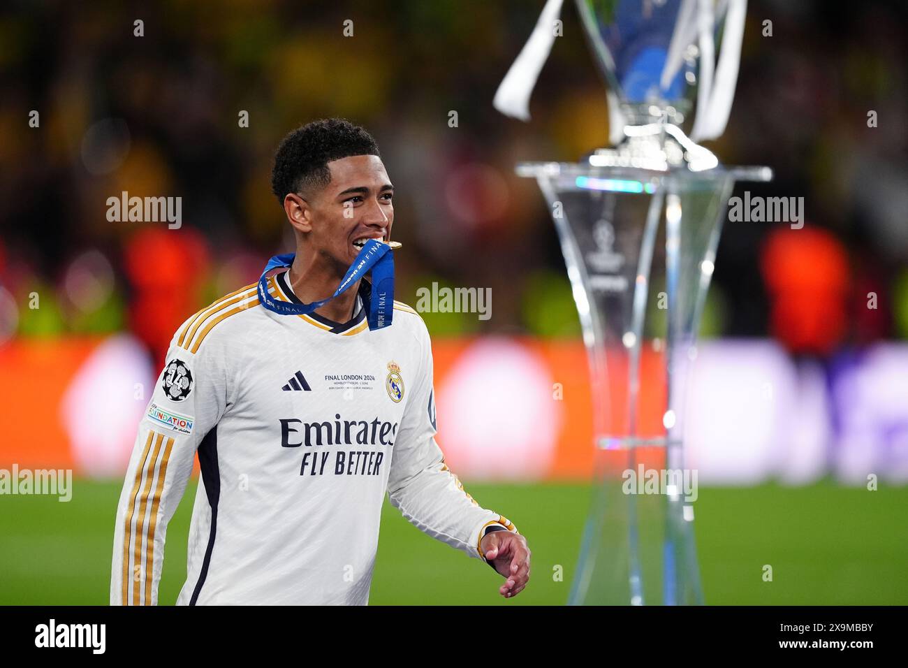 Real Madrid's Jude Bellingham bites his winners medal after winning the ...