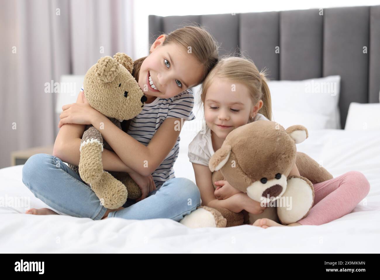 Cute little sisters with teddy bears on bed at home Stock Photo - Alamy