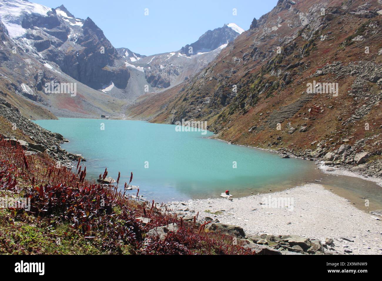 A serene alpine lake Sorasar, in Pahalgam Kashmir surrounded by snow ...