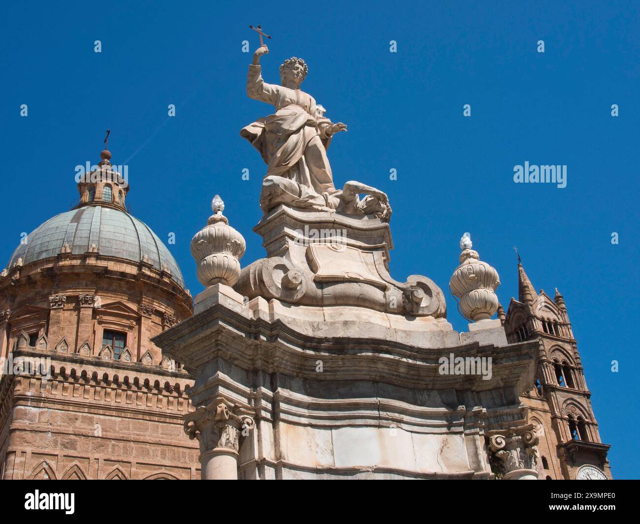 Baroque church structure with dome and stone statue holding a cross ...