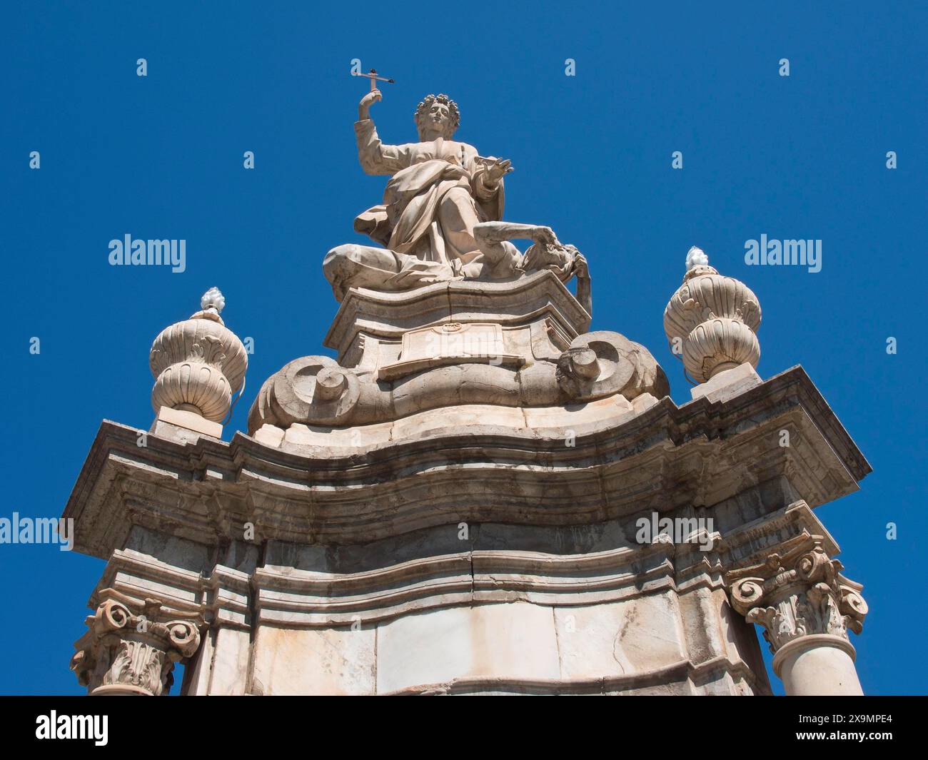 Detailed baroque statue with religious symbolism in front of a bright ...