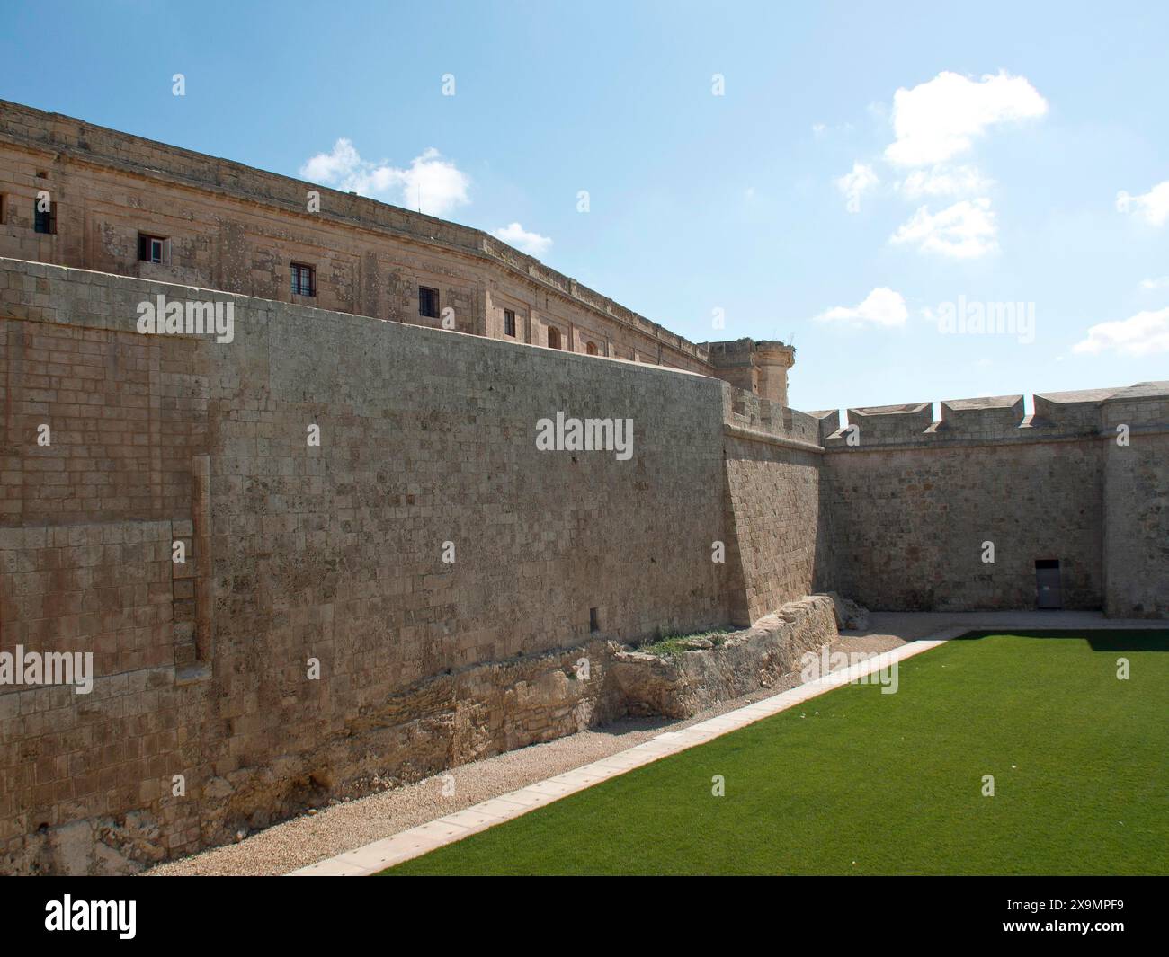 Massive stone walls of a fortress with a visible courtyard on a sunny ...