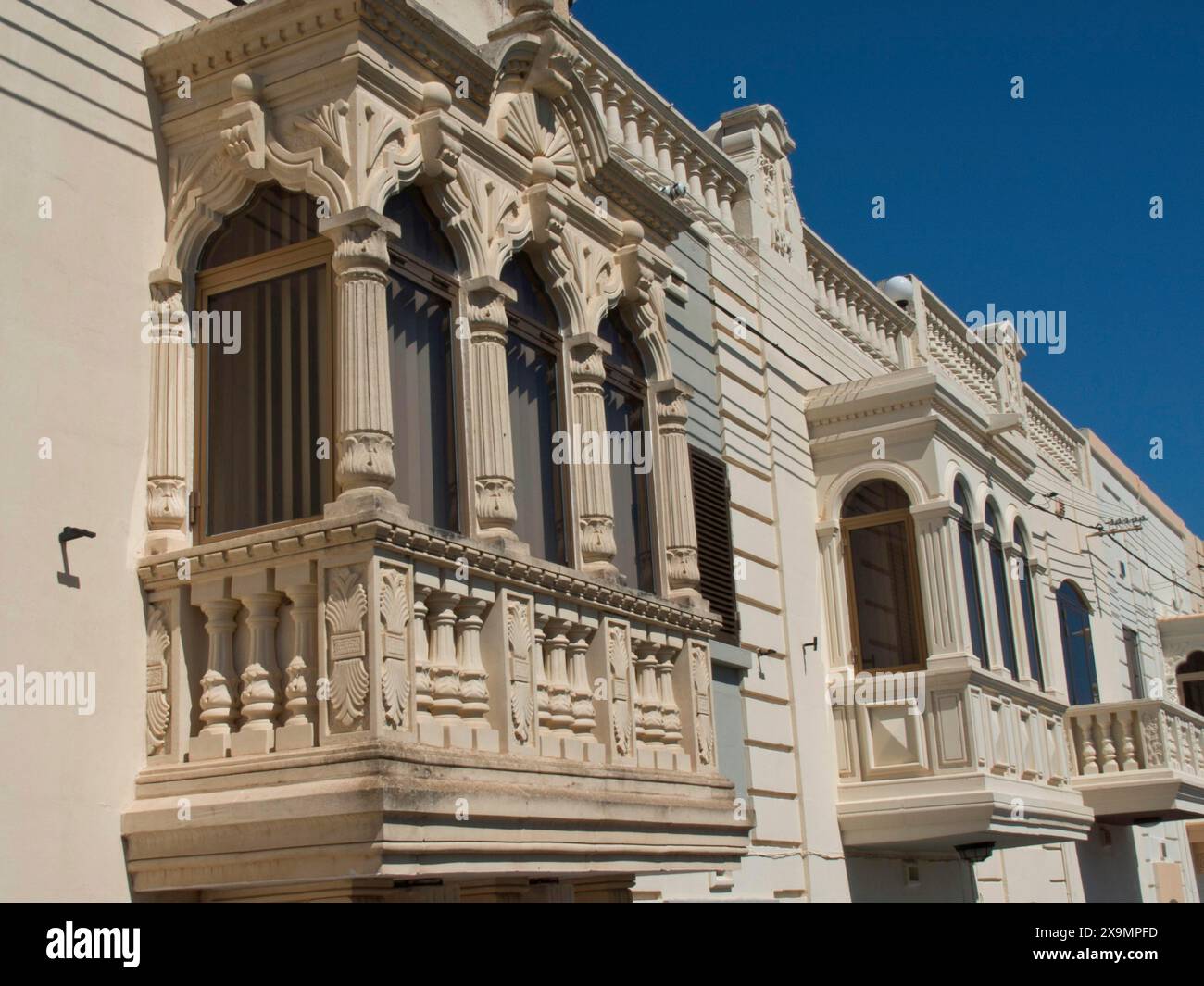 Historic building with ornate balconies and windows under a clear blue ...
