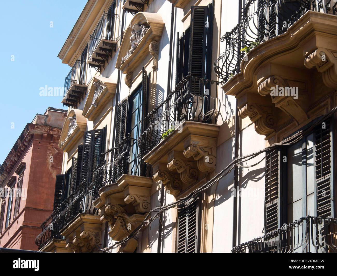 Historic buildings with wrought iron balconies and black shutters in a ...