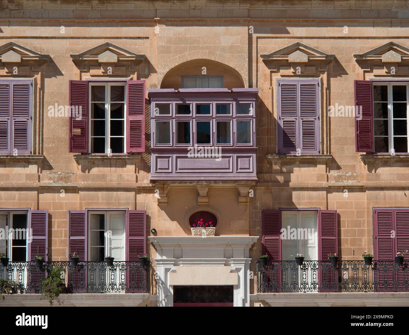 Building facade with purple shutters and small balconies, the town of ...