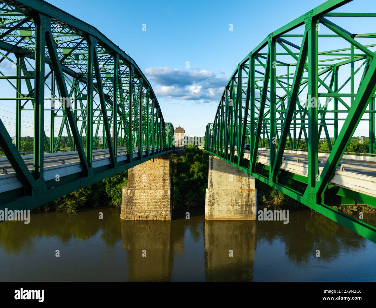 A photograph capturing the underside of a green steel bridge over a ...